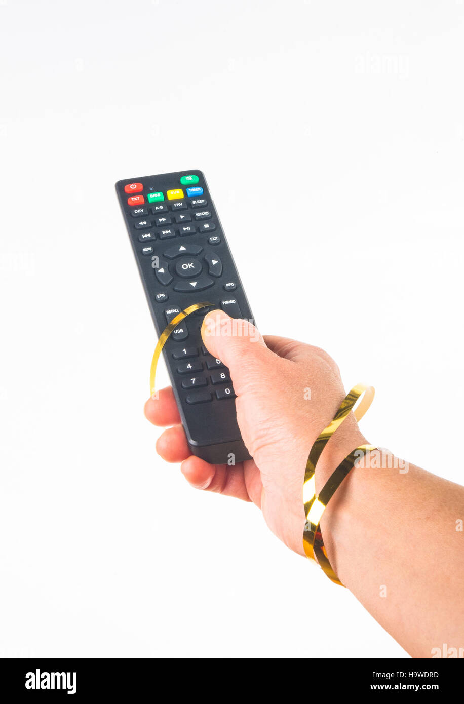 hand holding a remote control in a festive gold ribbon on white ...