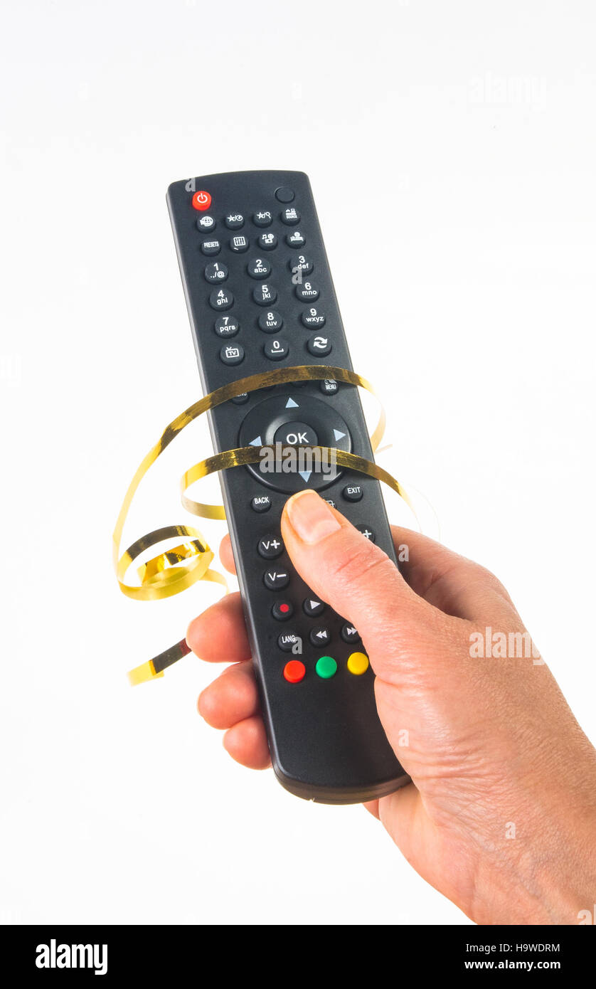 hand holding a remote control in a festive gold ribbon on white ...