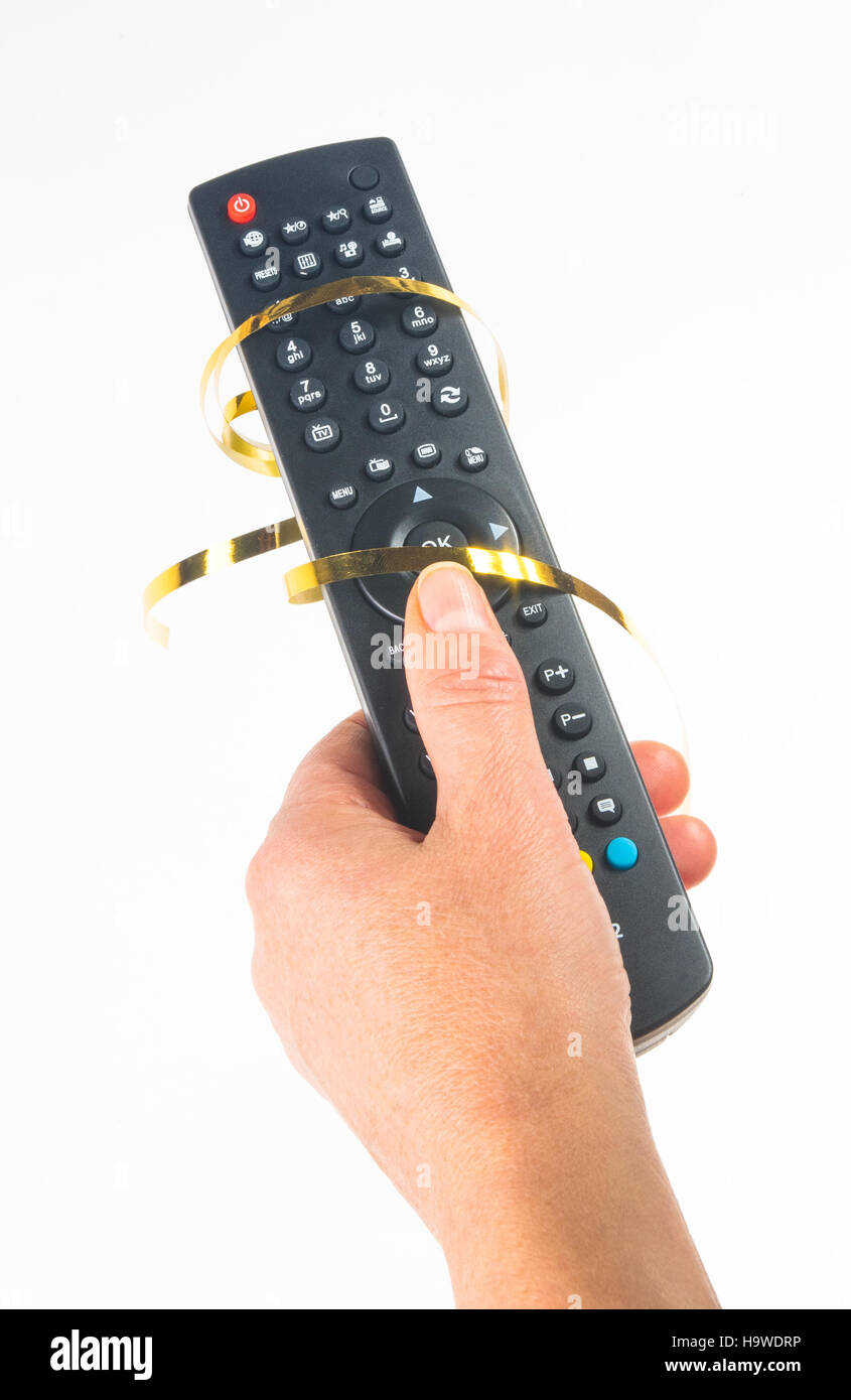 hand holding a remote control in a festive gold ribbon on white ...