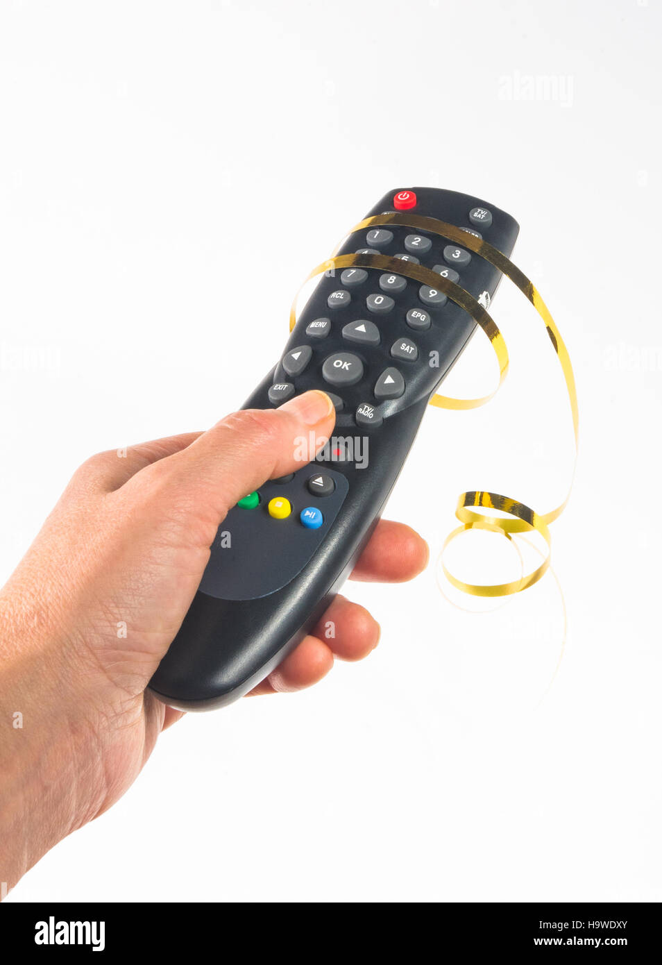 hand holding a remote control in a festive gold ribbon on white ...