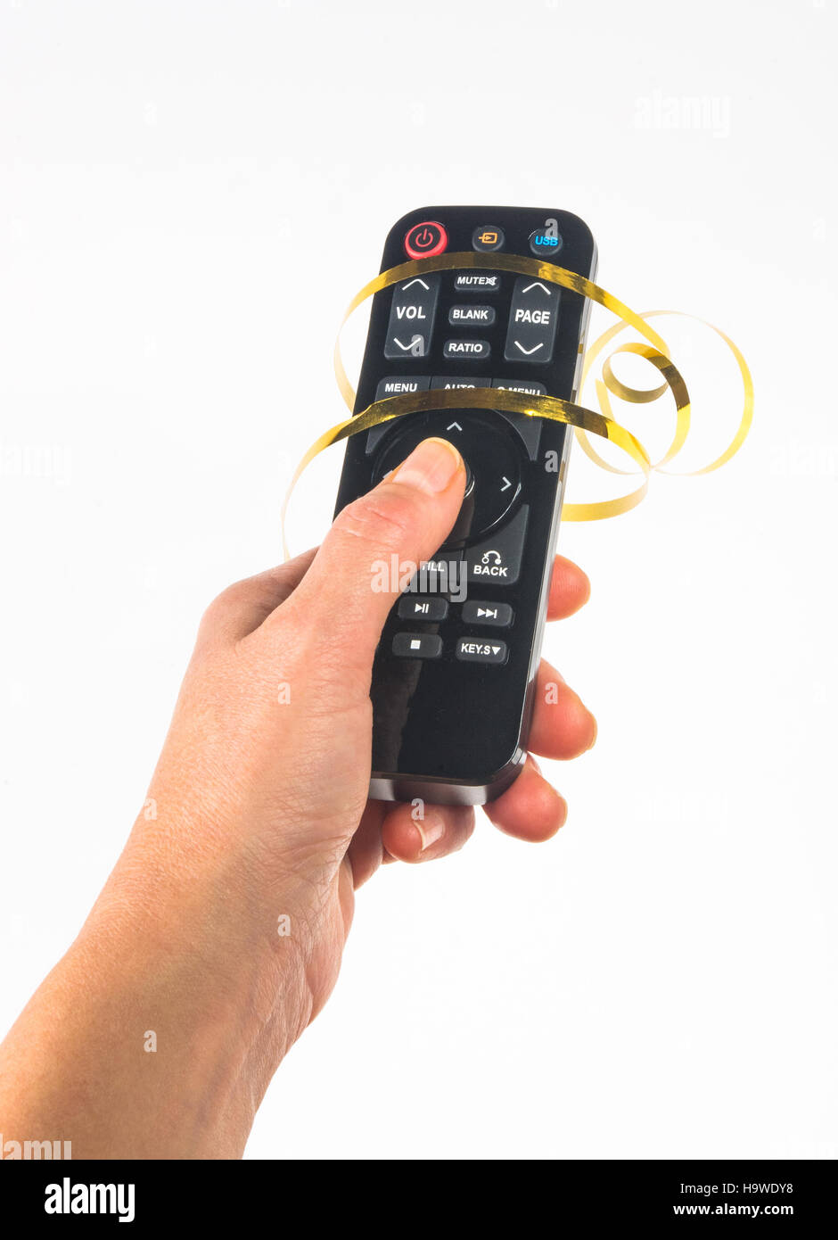 hand holding a remote control in a festive gold ribbon on white ...