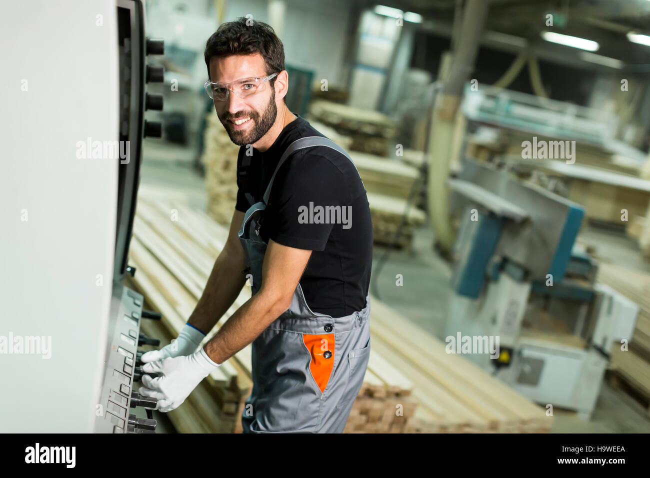 Young worker works in a factory for the production of furniture Stock ...