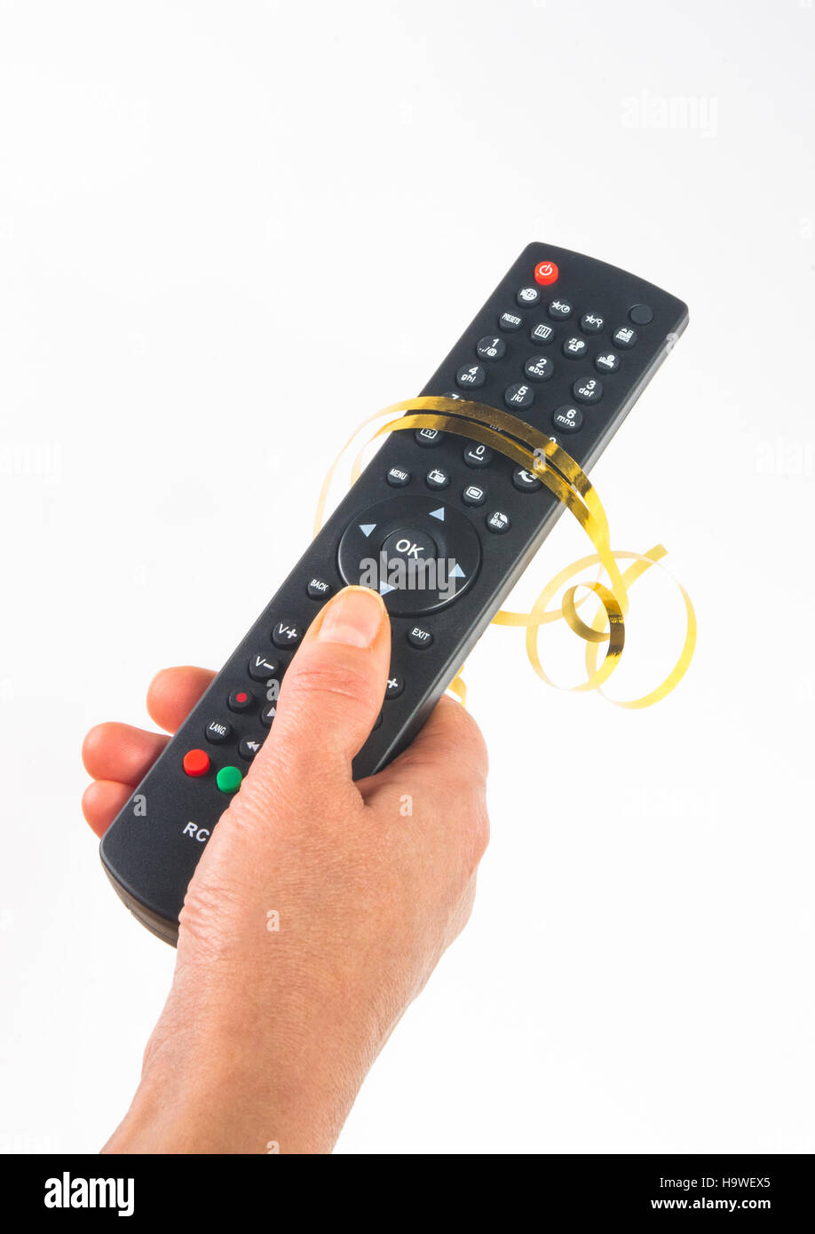 hand holding a remote control in a festive gold ribbon on white ...
