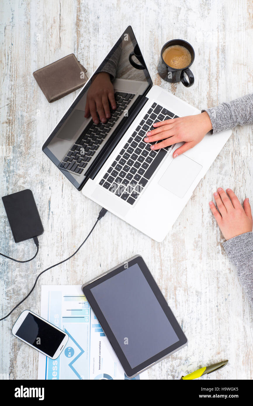 A working woman’s hand at a table with laptop,tablet and phone Stock ...