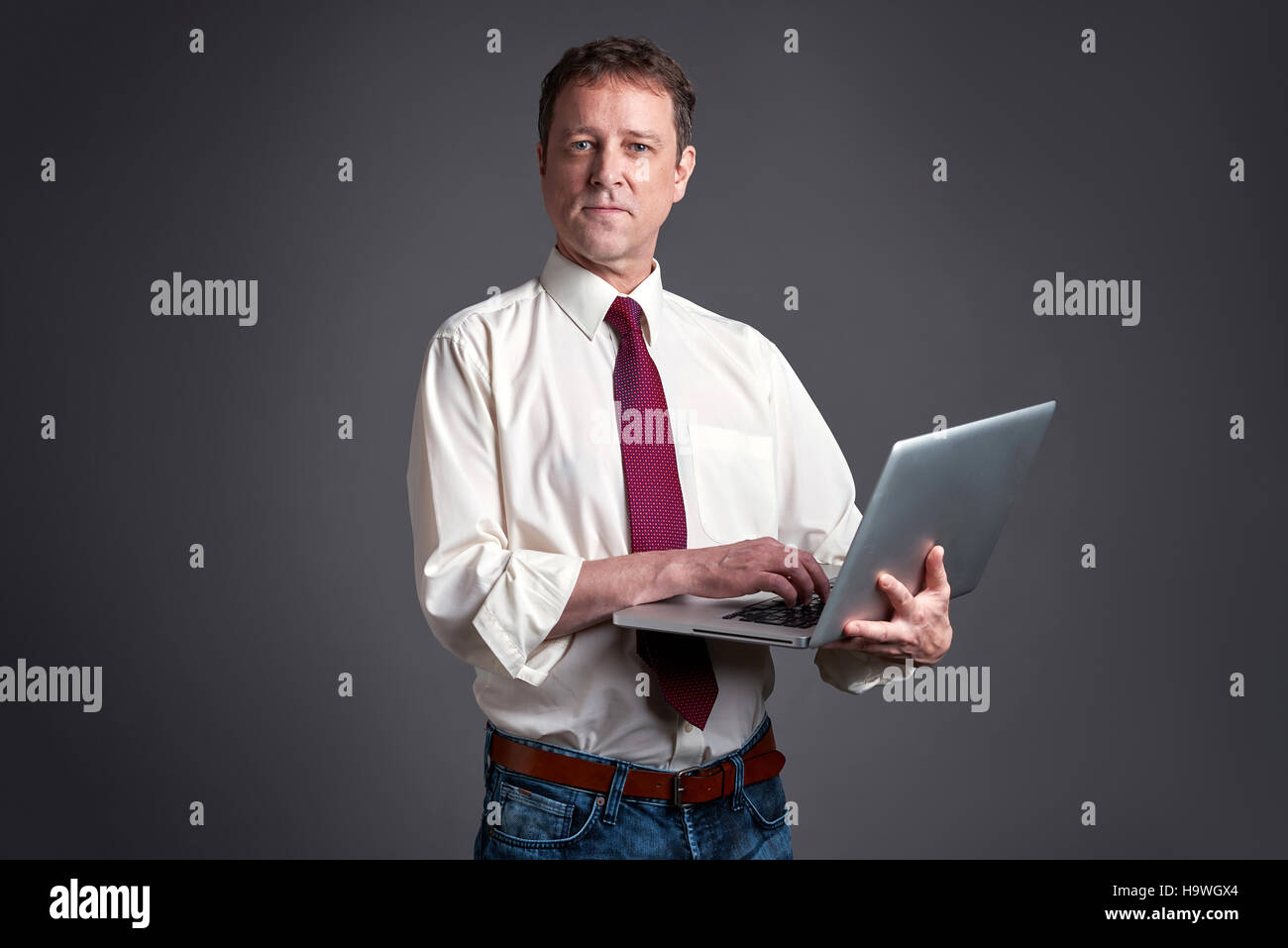 A confident middle age man with a laptop Stock Photo - Alamy
