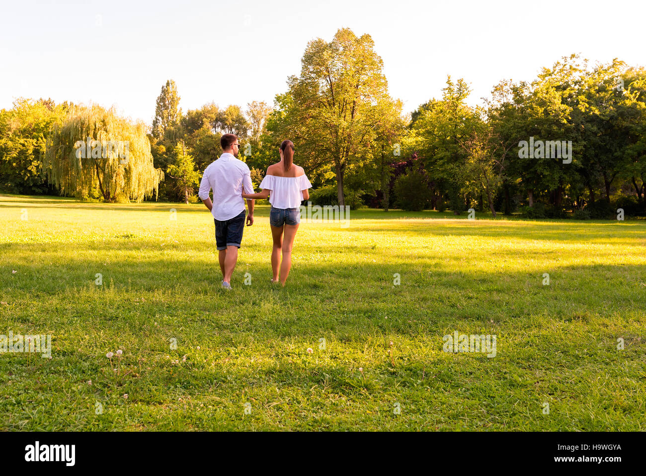 A beautiful young european couple having a walk together in a park in ...