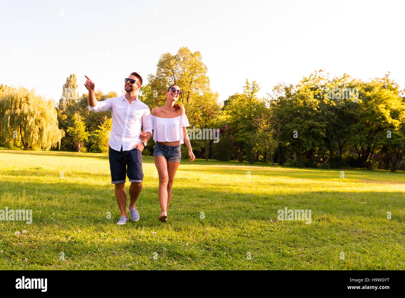 A beautiful young European couple having a walk together in a park in ...