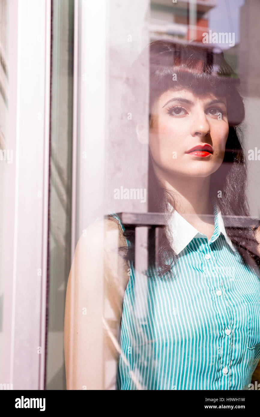 A vintage styled woman sitting beside the window Stock Photo - Alamy