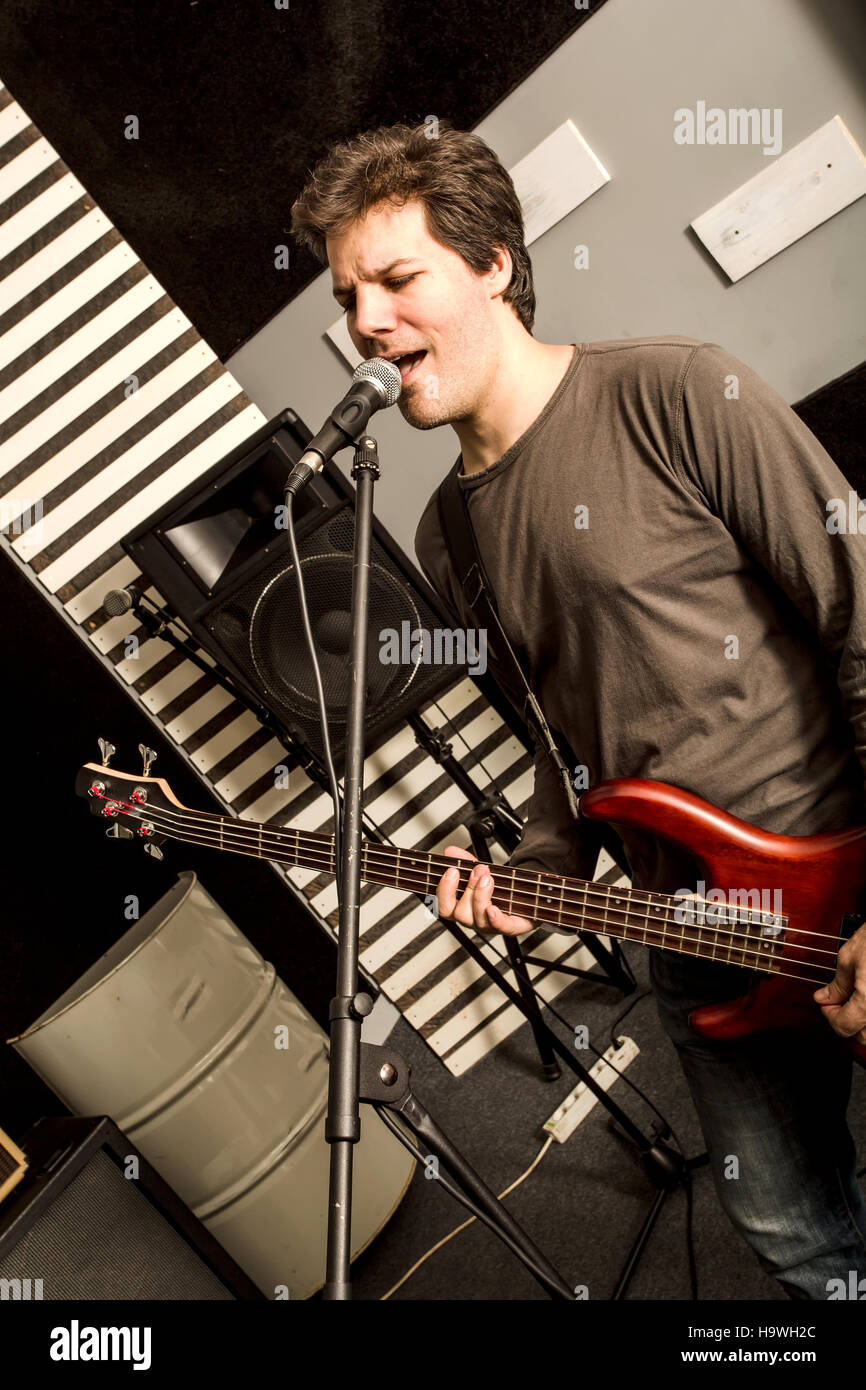 A Rock singer playing bass in the rehearsal Studio Stock Photo - Alamy