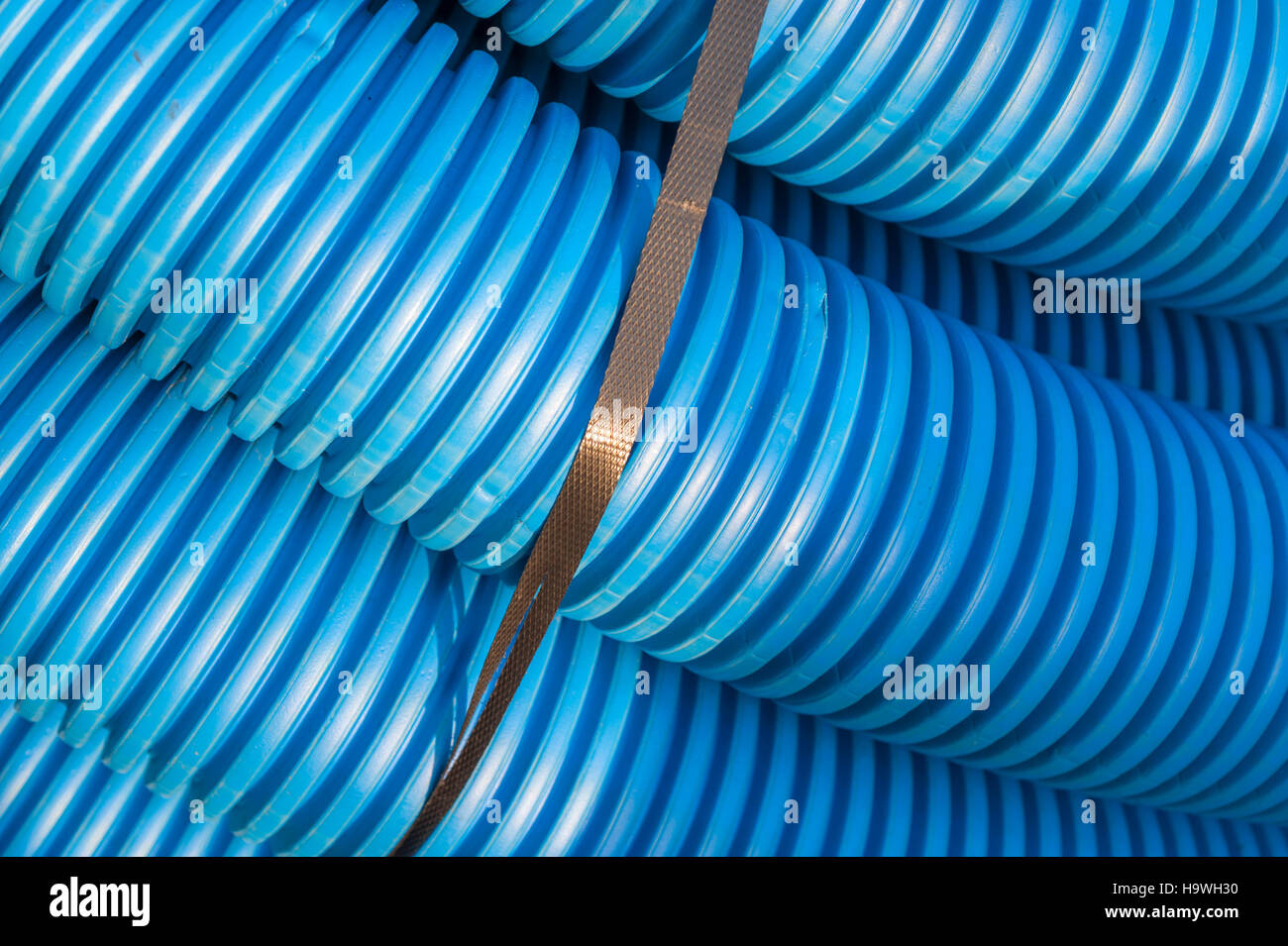 reels of plastic pipes used for land drains reeled up in builders yard ...