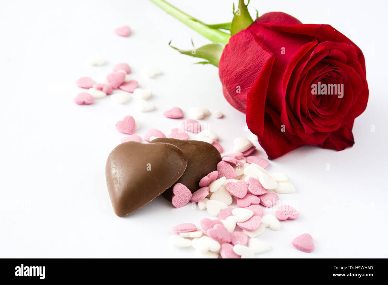 Red rose, chocolate bonbon with heart shape and candies Stock Photo - Alamy