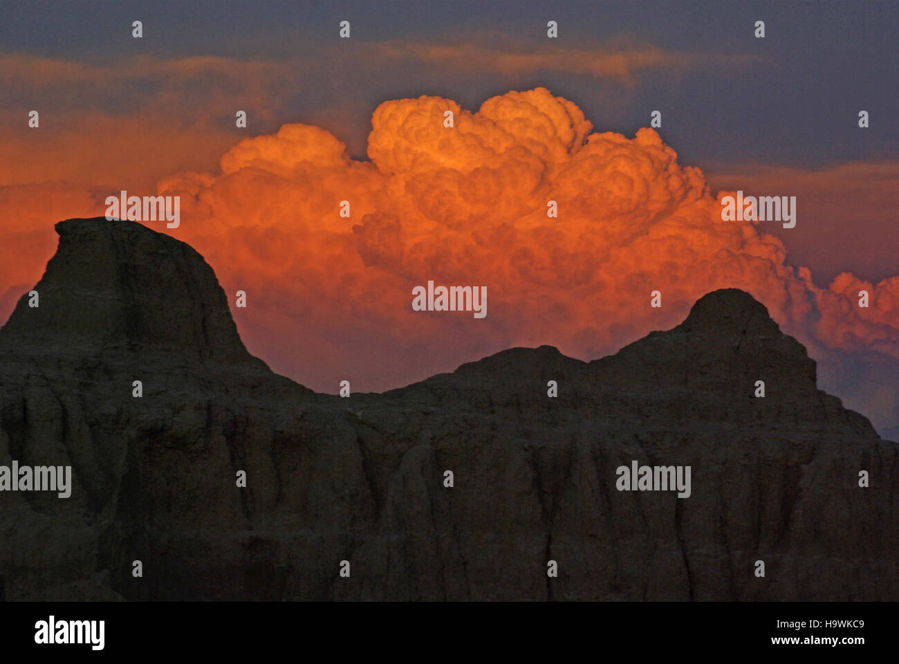 The dramatic sunset over the Badlands National Park highlights the park ...
