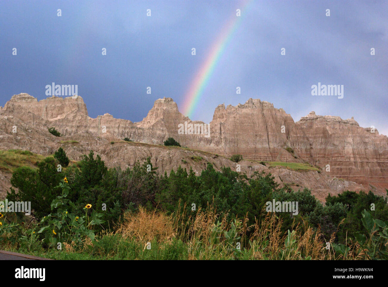 A beautiful rainbow forms over the cliff shelf in Badlands National ...