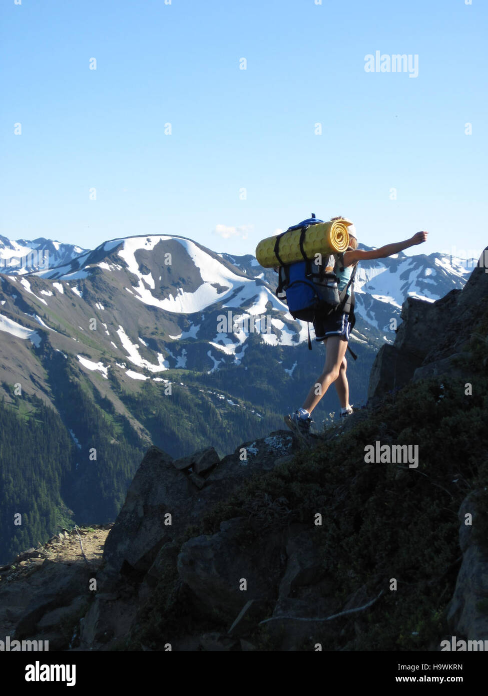 This image shows a child backpacking through a scenic mountain trail in ...
