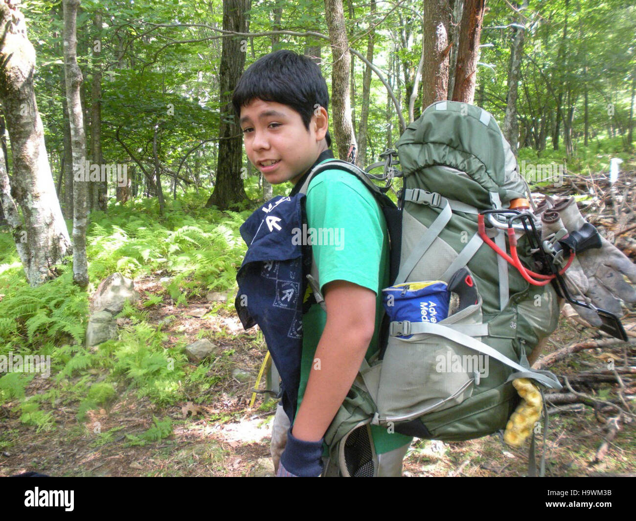 A hiker tries on a fully packed backpack in preparation for an outdoor ...