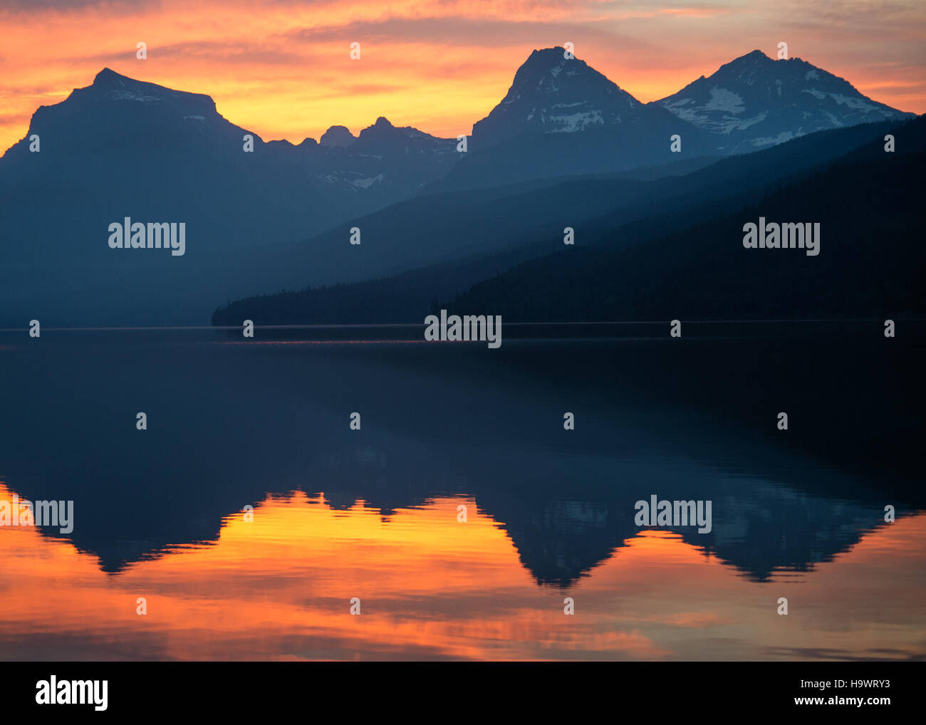 A subtle sunrise over Glacier National Park, casting a soft light over ...