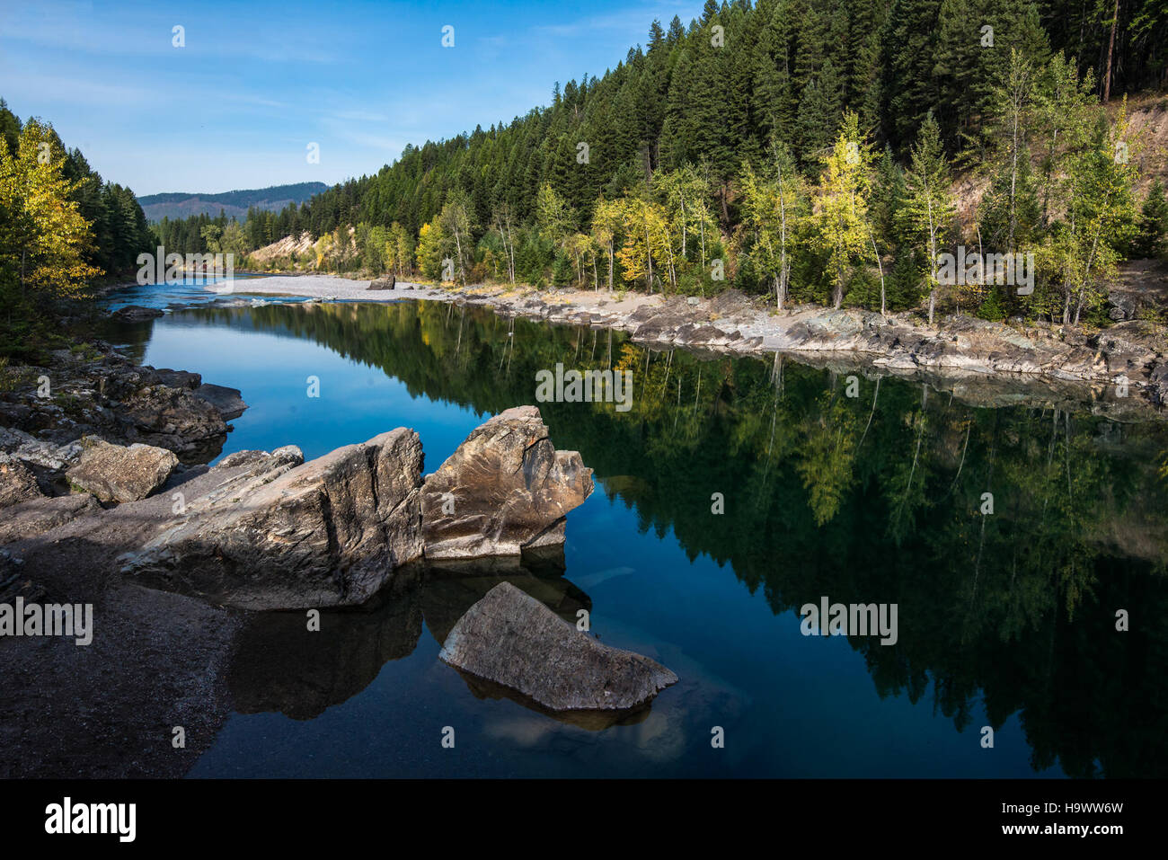 Flathead River in Glacier National Park reflects a calm morning scene ...