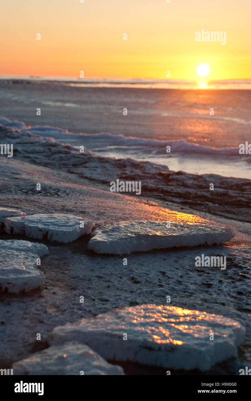 The sunrise over the Bering Sea highlights the vast, icy expanse of the ...