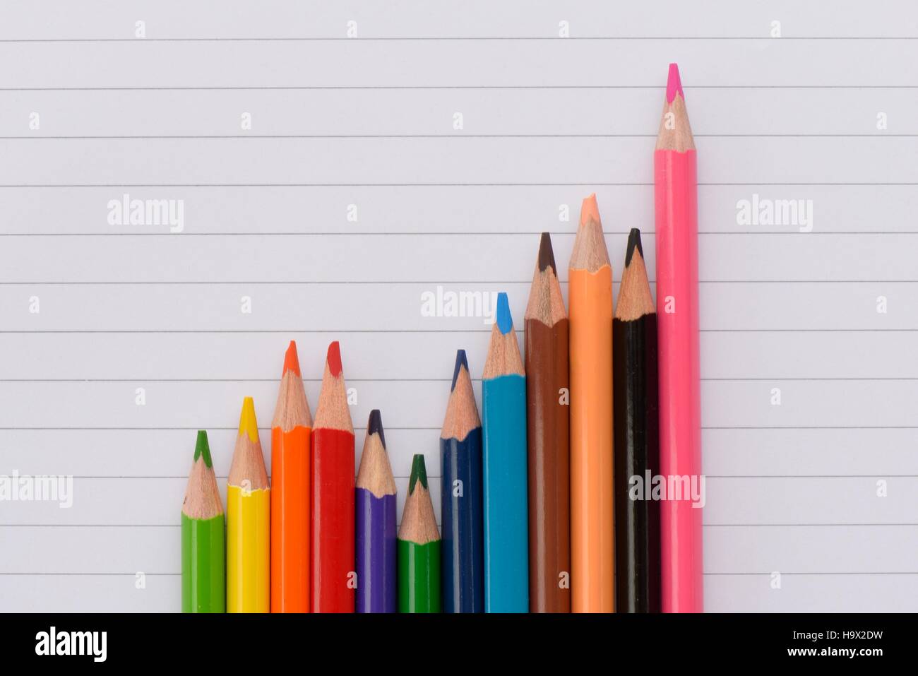 Coloured pencils form an upward graph on lined paper Stock Photo - Alamy