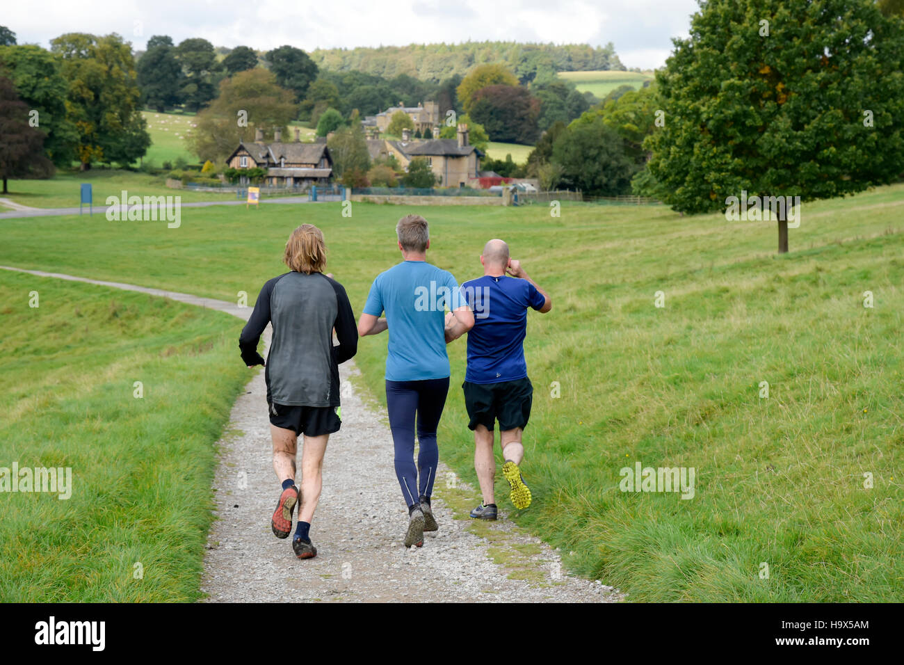 Three people running down small track Derbyshire Stock Photo - Alamy