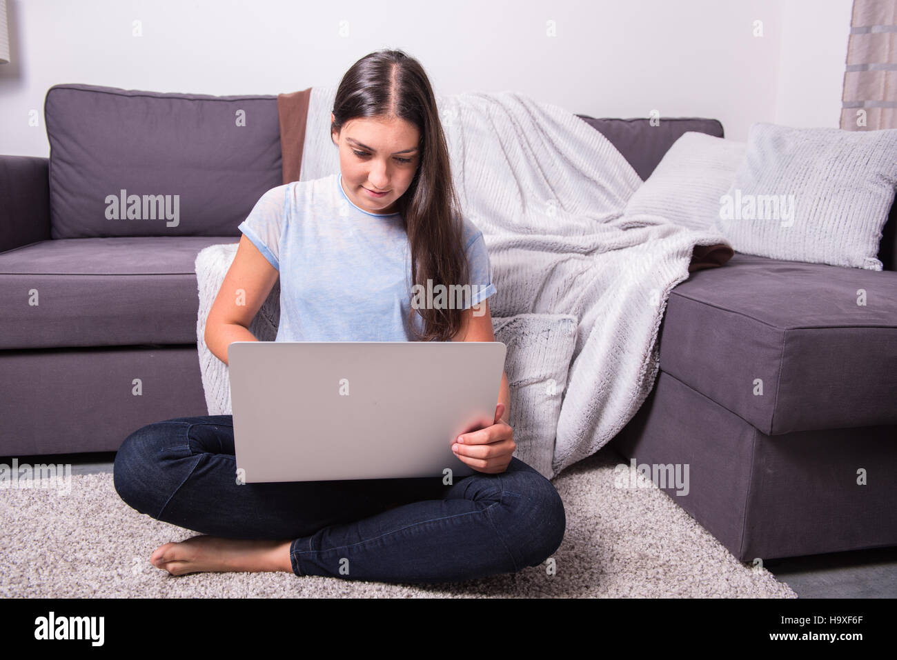 Young attractive woman sitting on the floor and working with computer ...