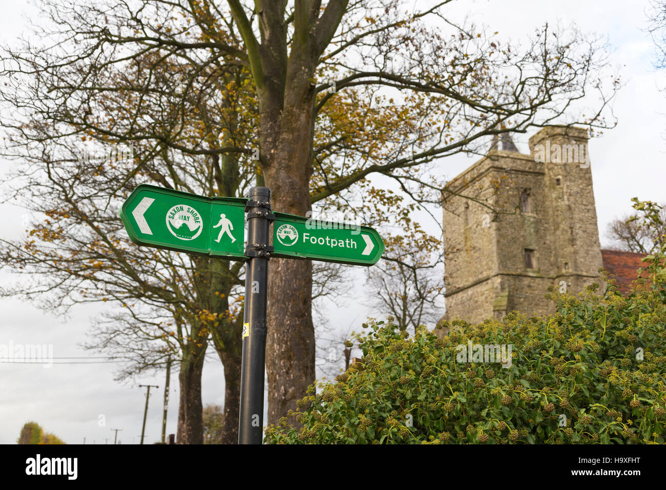 Footpath sign with St James' Church in the background, Cooling, Kent ...