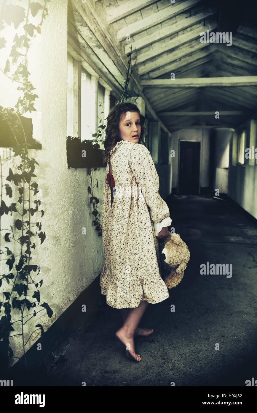 Young girl walking down a decaying corridor Stock Photo - Alamy