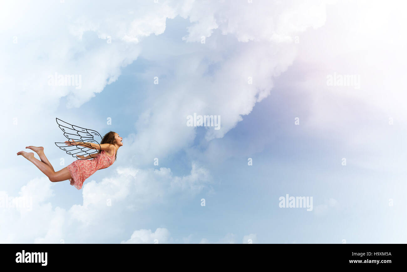 Young woman flying high in blue sky Stock Photo - Alamy