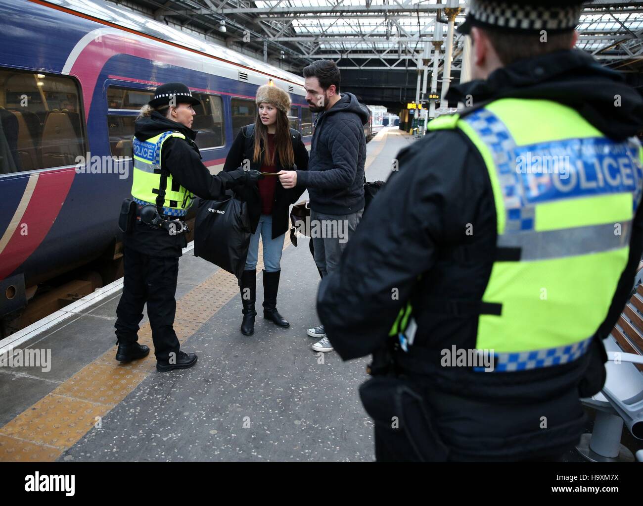 British Transport Police officers hand out leaflets to members of the ...