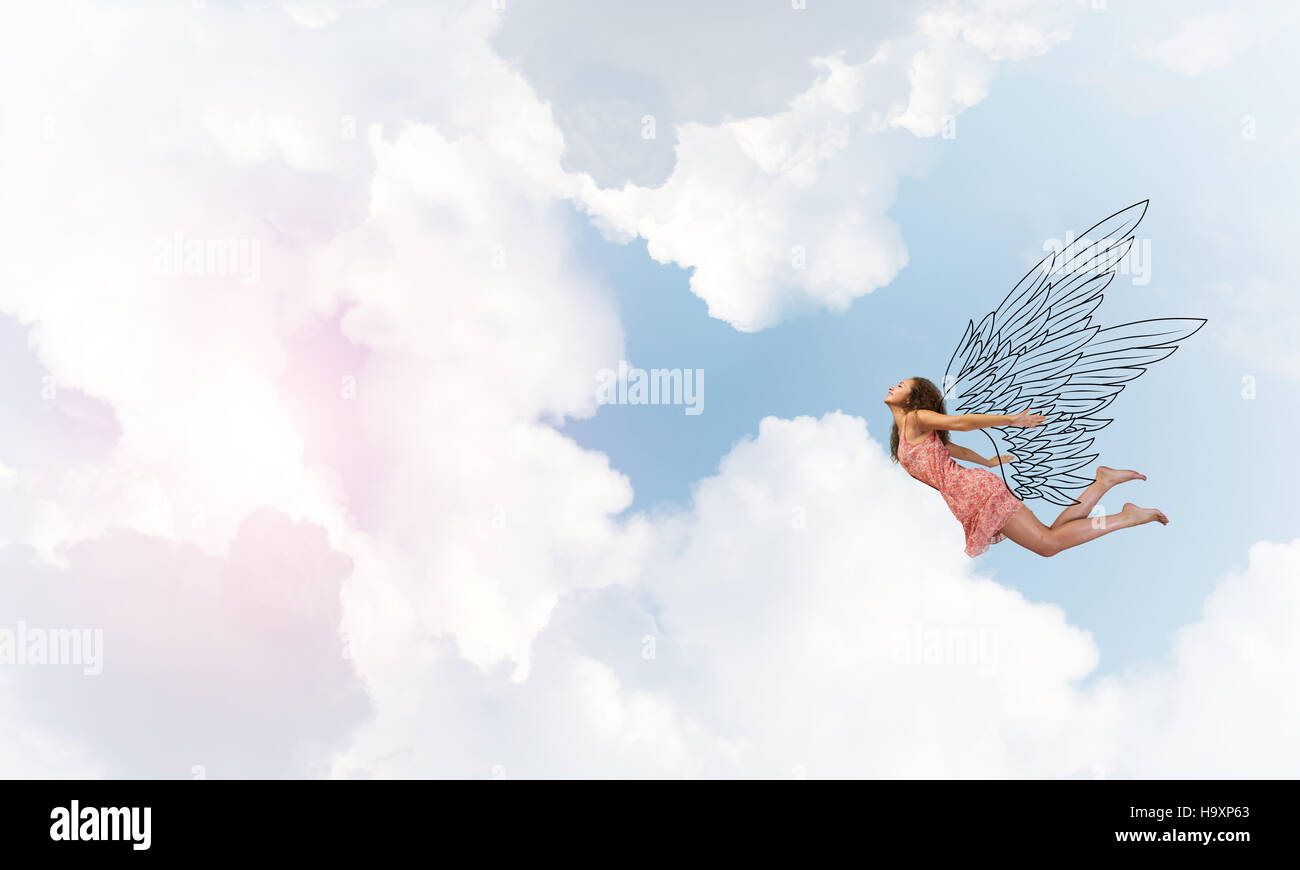 Young woman flying high in blue sky Stock Photo - Alamy