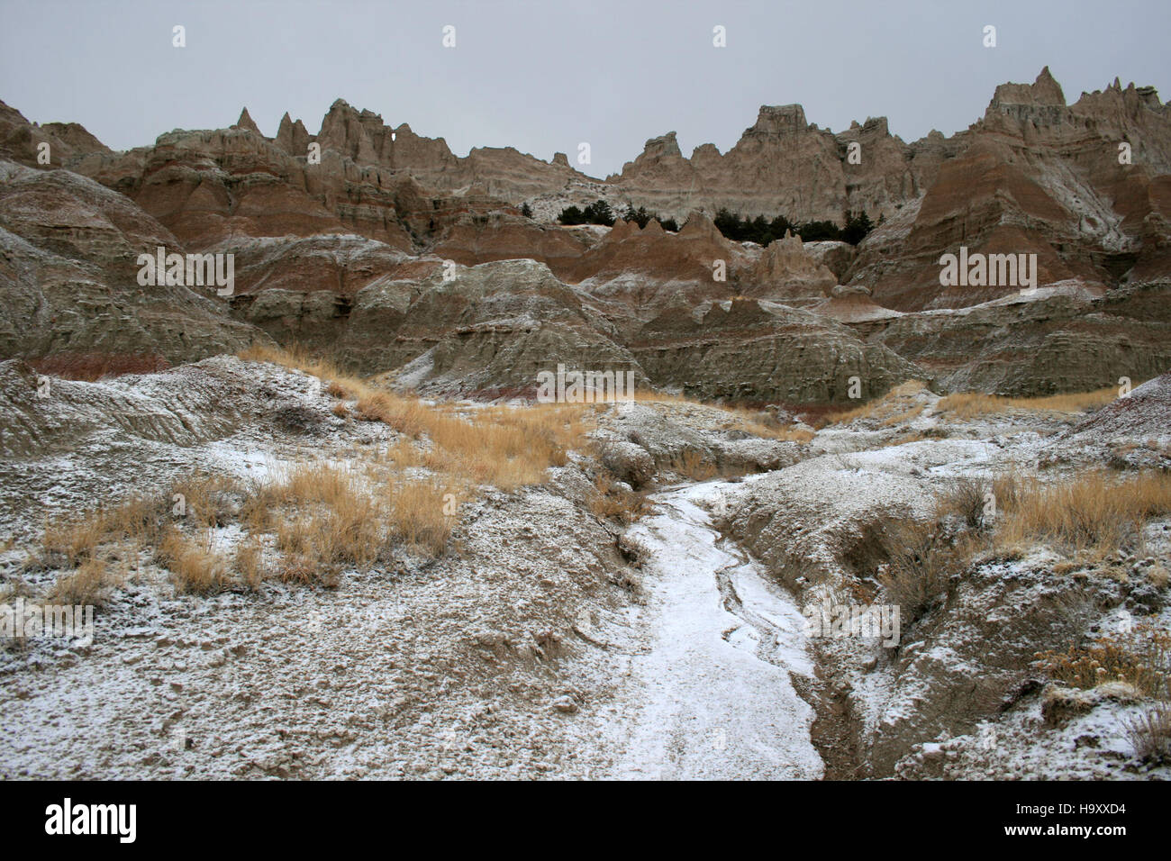 A snowy drainage in Badlands National Park showcases the striking ...