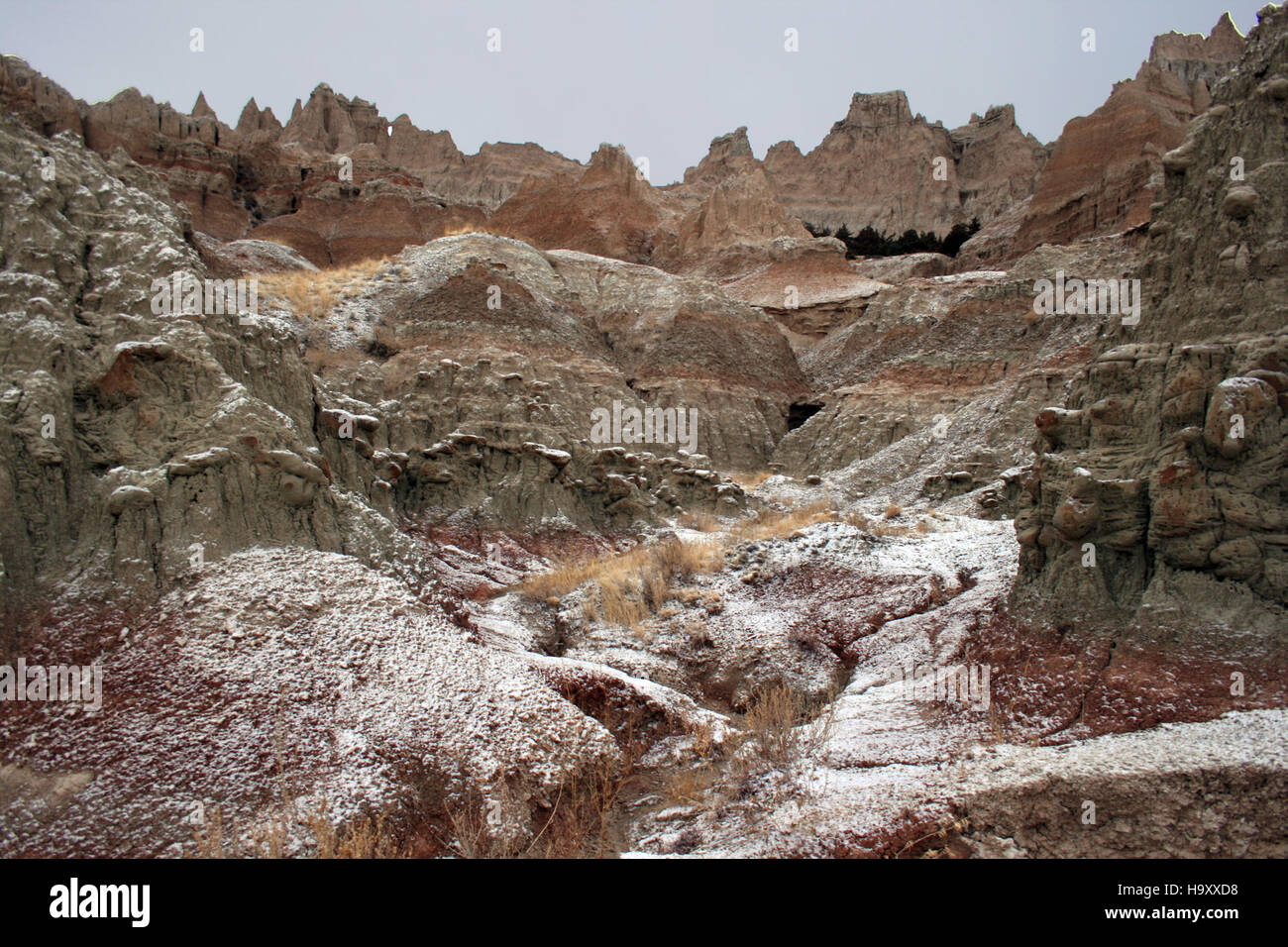 Snow lightly dusts the unique geological formations of Badlands ...