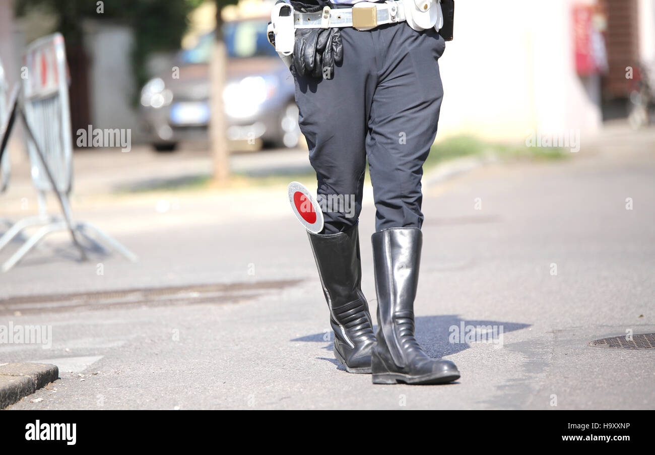 policeman with black boots in a checkpoint while checking motorists ...