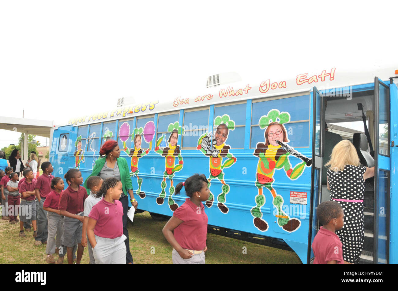 The image shows a mobile food bus serving children in a national park ...