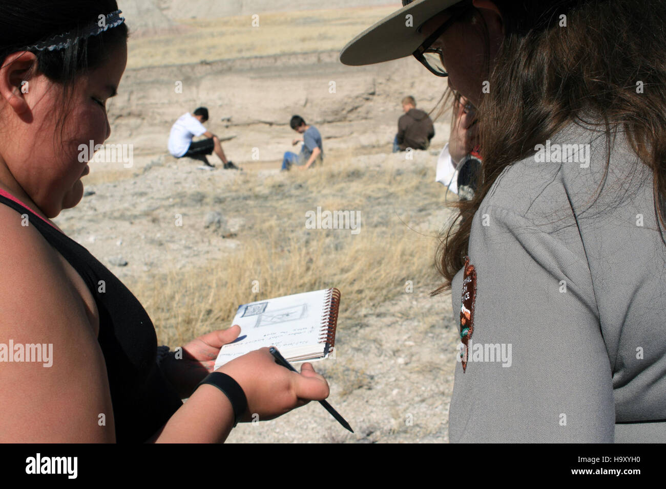 A student shares her nature journal with a Park Ranger at Badlands ...