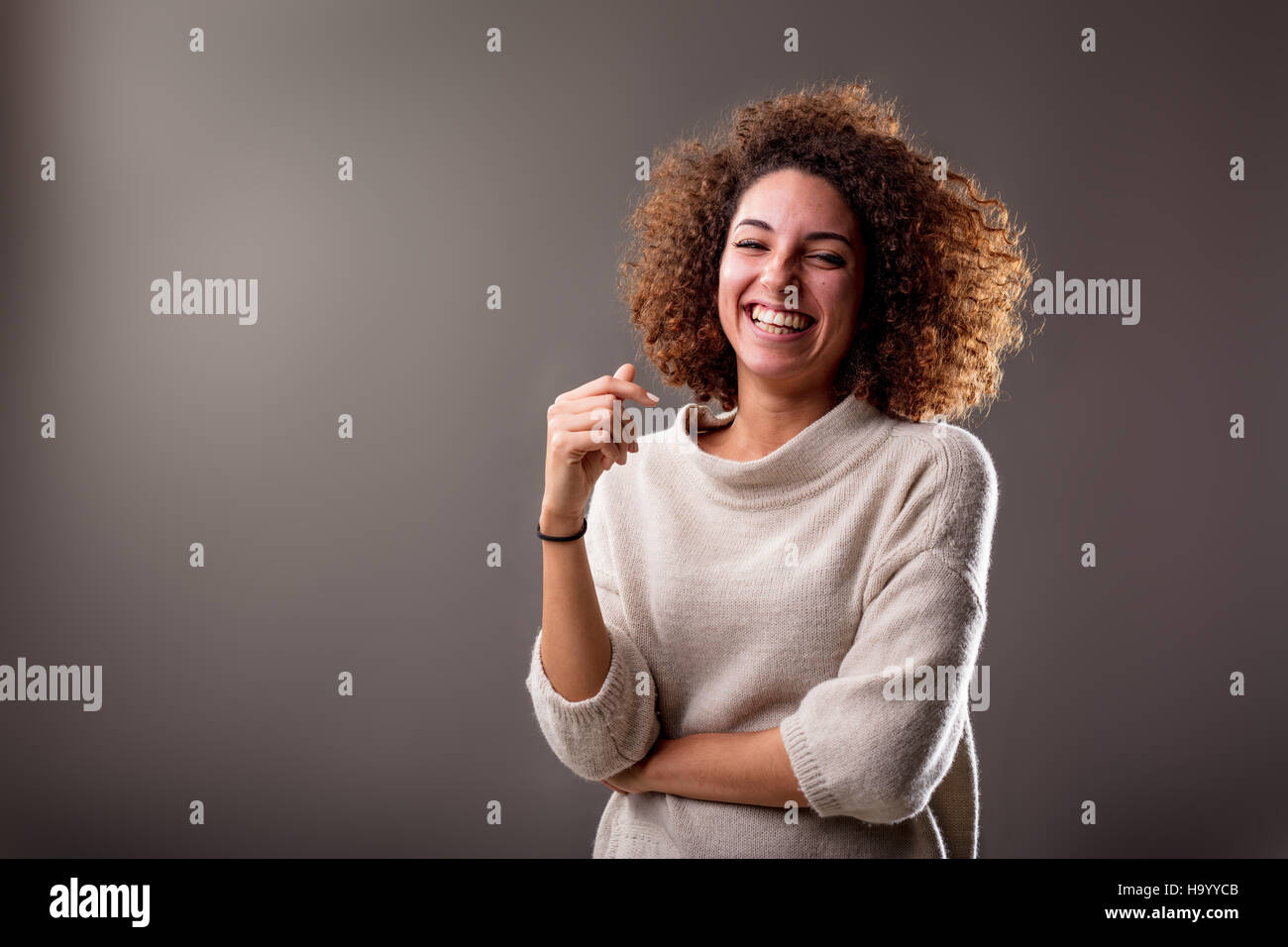 happy curly south-american woman laughter on a dark background Stock ...
