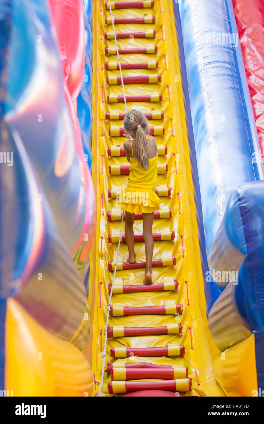 Girl with a rope climbs a high hill on the trampoline Stock Photo - Alamy