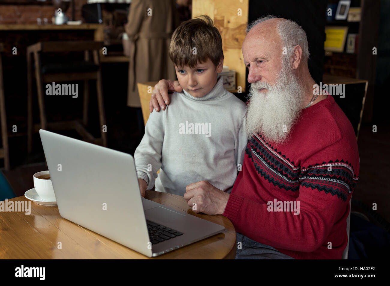 Grandfather and grandson using laptop together Stock Photo - Alamy