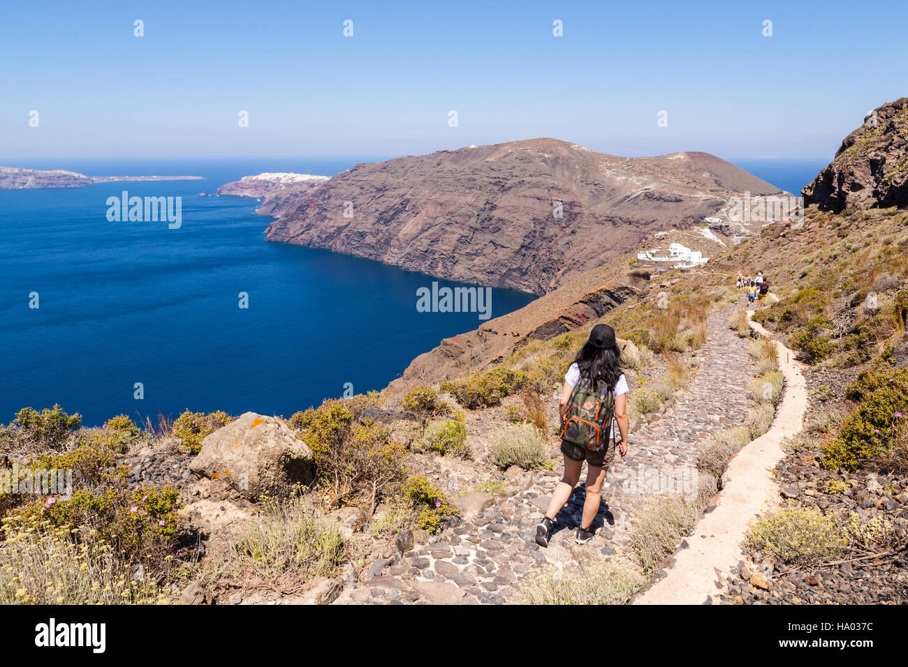 Young girl hiking along the volcano rim from Fira to Oia on the Greek ...