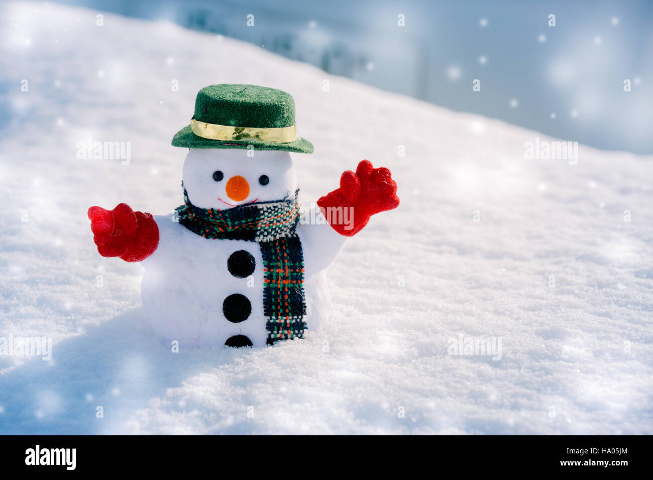 Snow man stand among pile of snow. Morning sunshine is warming in ...