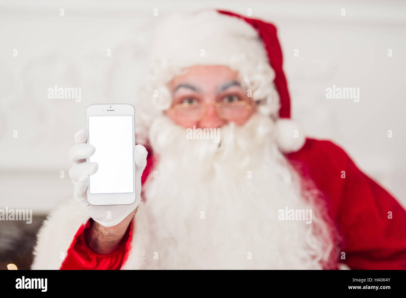 Santa Claus shows a smartphone on white background Stock Photo - Alamy