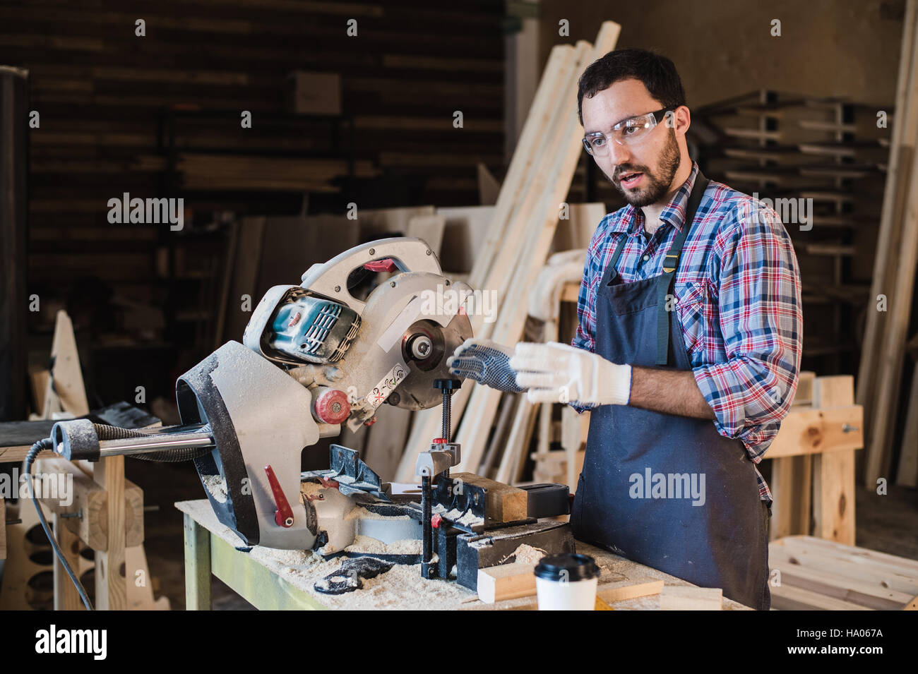 Young craftsman in uniform working at carpentry Stock Photo - Alamy