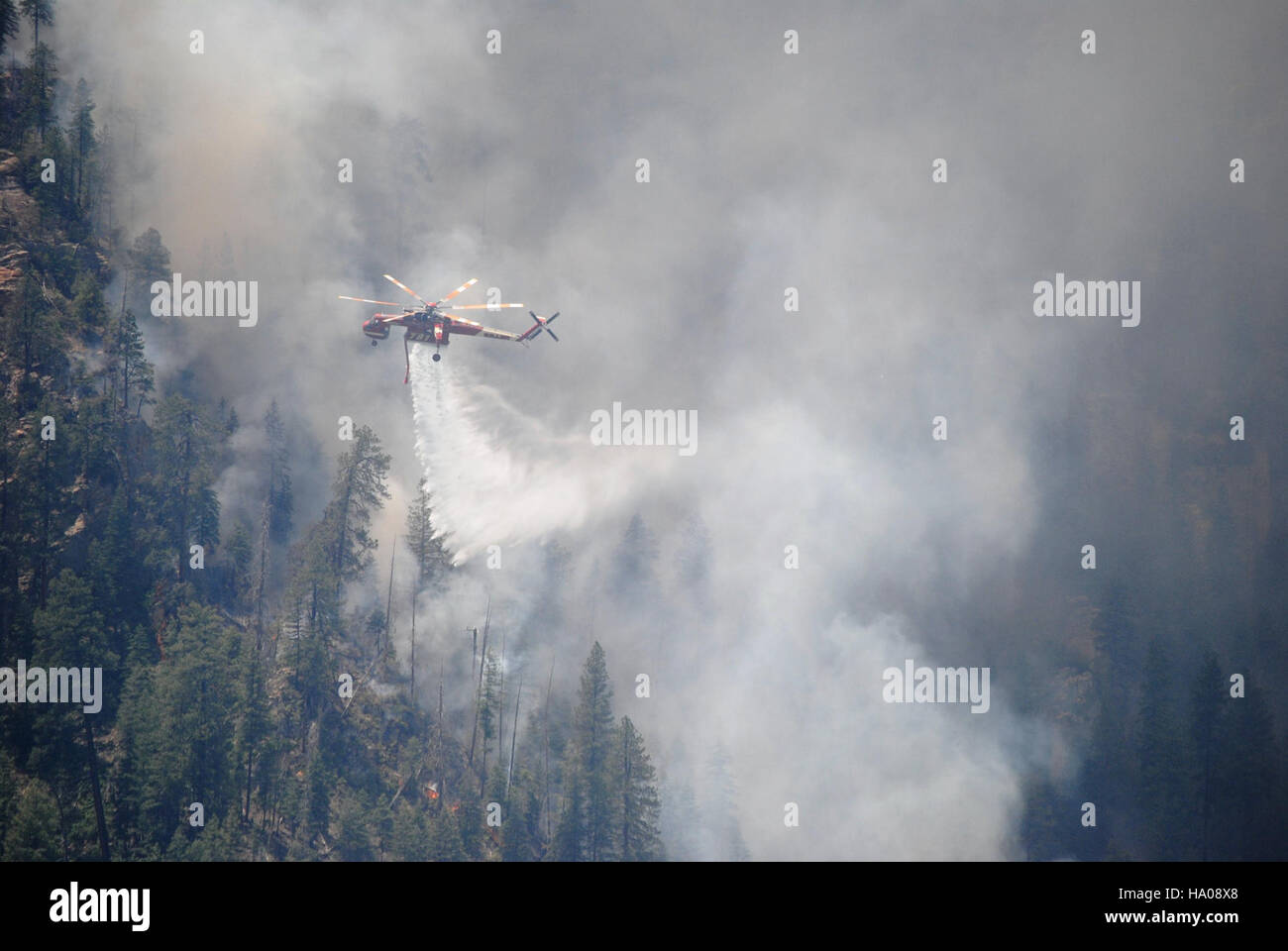 A firefighter uses a helicopter during a wildfire in an effort to ...