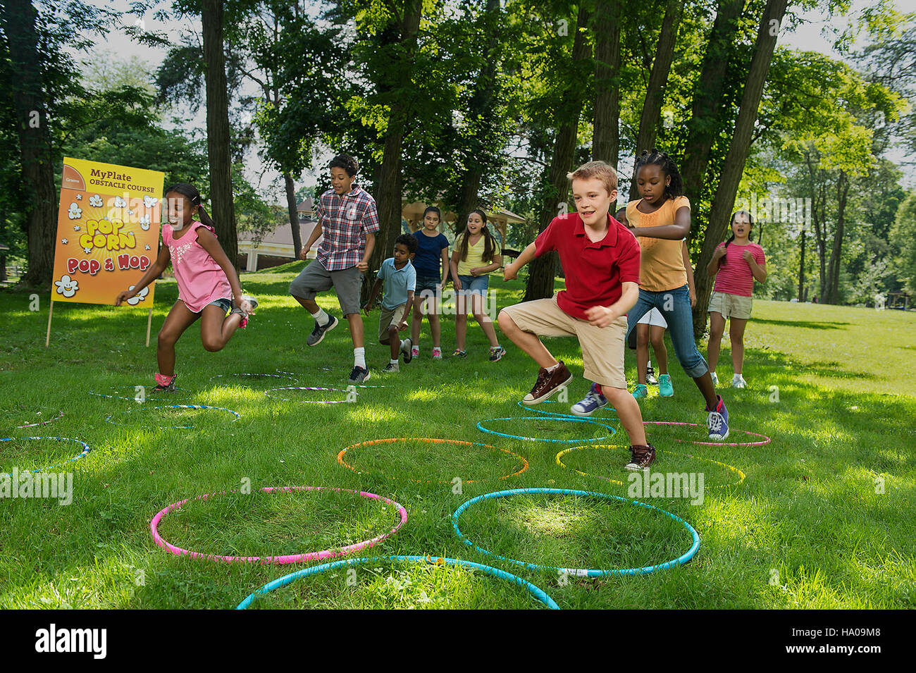 Children participate in a physical activity involving jumping through ...