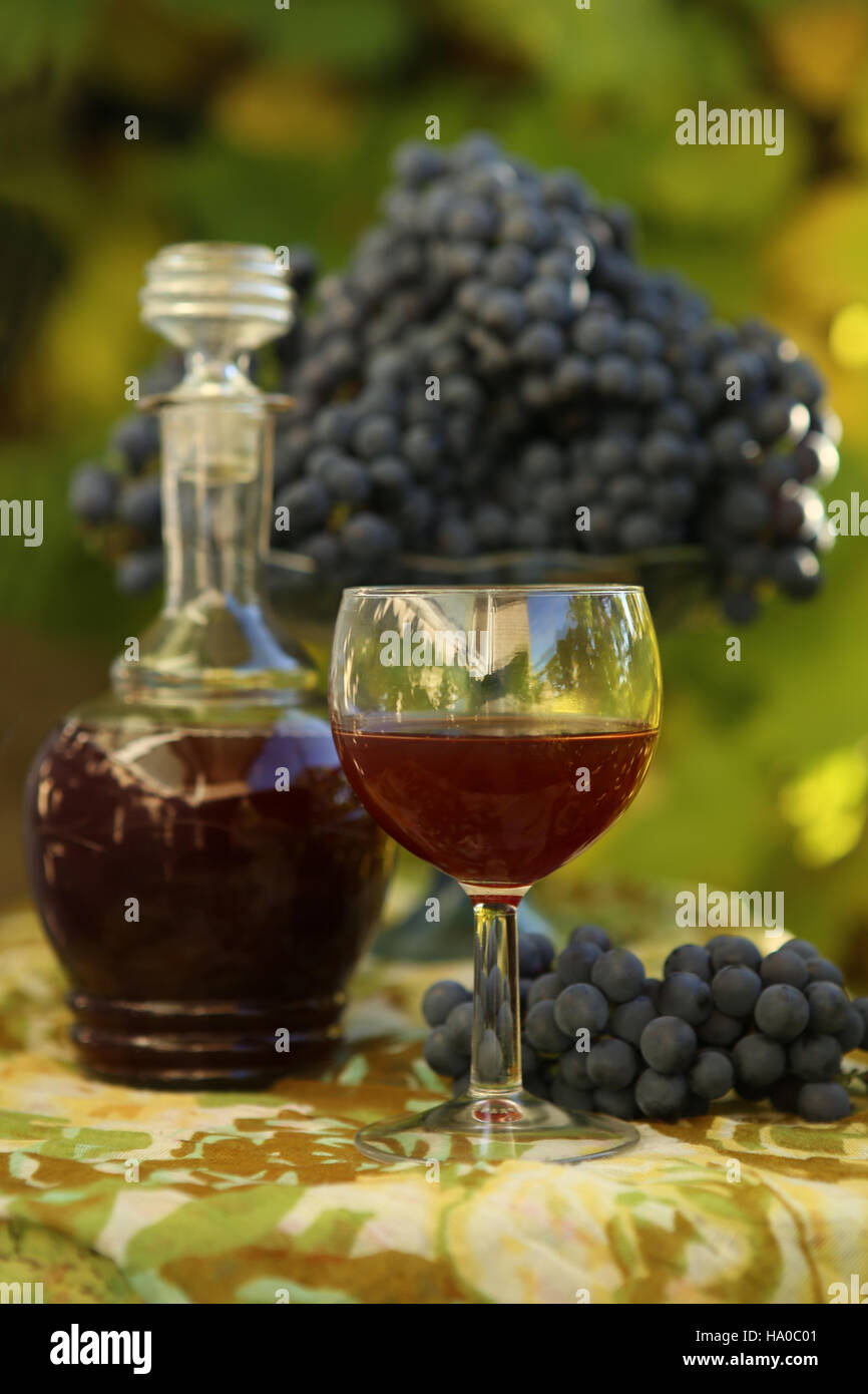 Homemade wine from grapes. Decanter, glass, grapes photographed against the background of the ...