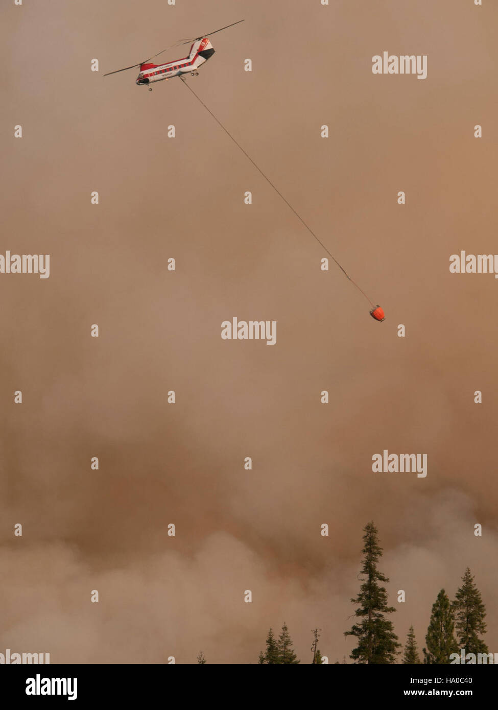 A firefighting helicopter conducts a water drop over the Happy Camp ...