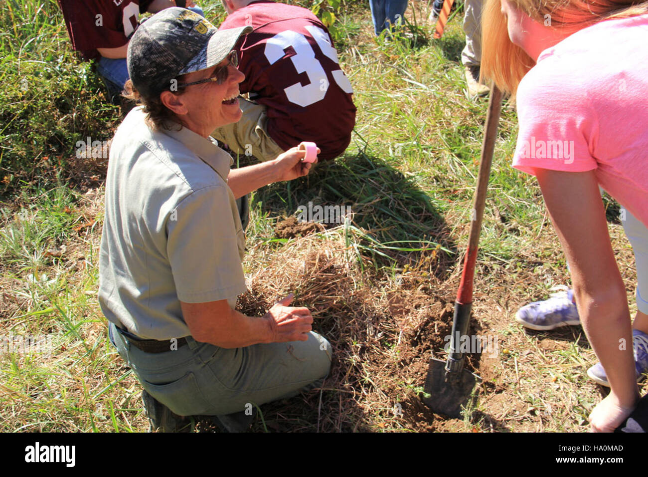 Mitzi Cole from the US Forest Service works with students to plant ...