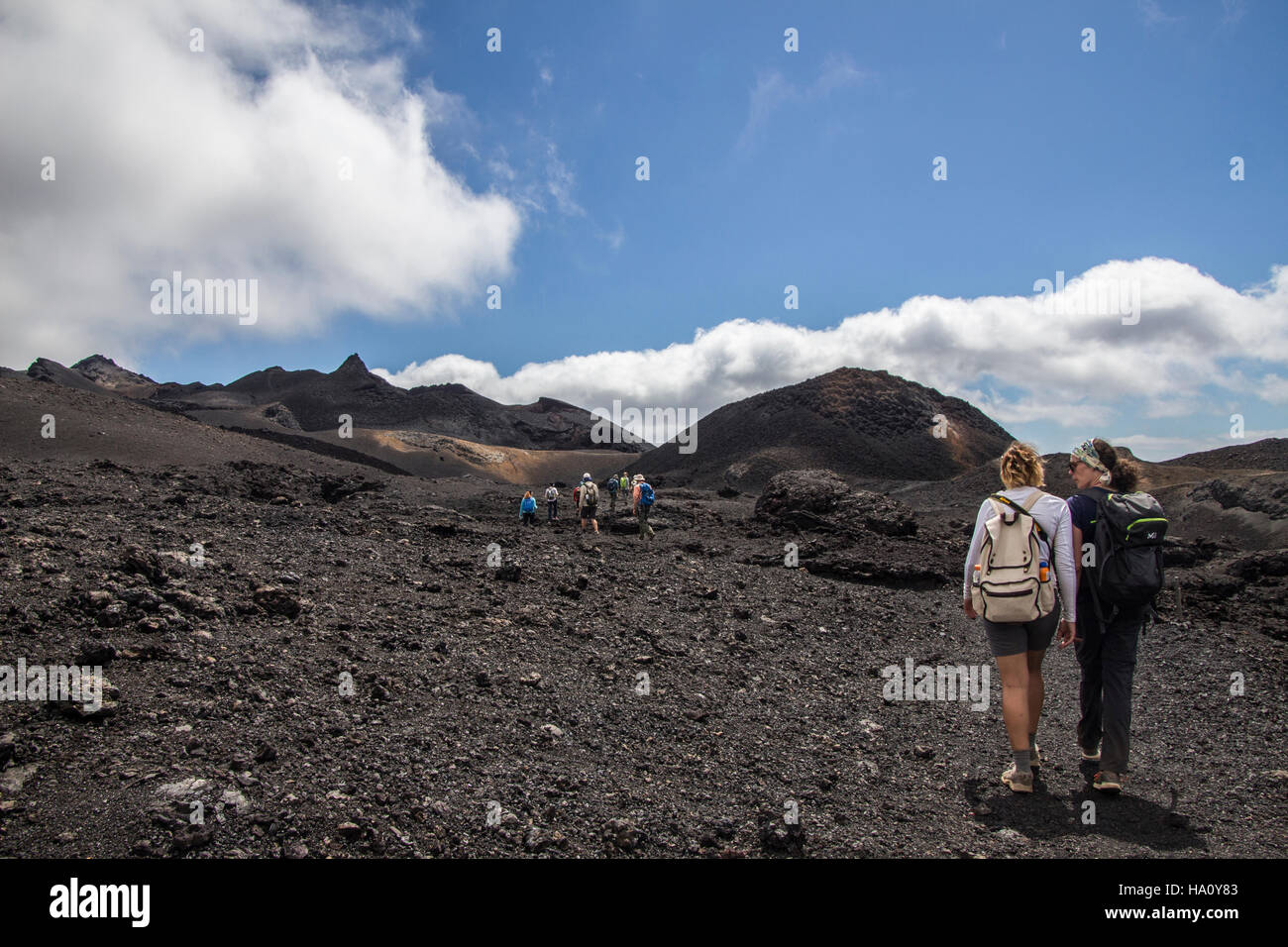 People walking in a volcanic island formation in Galapagos Ecuador ...