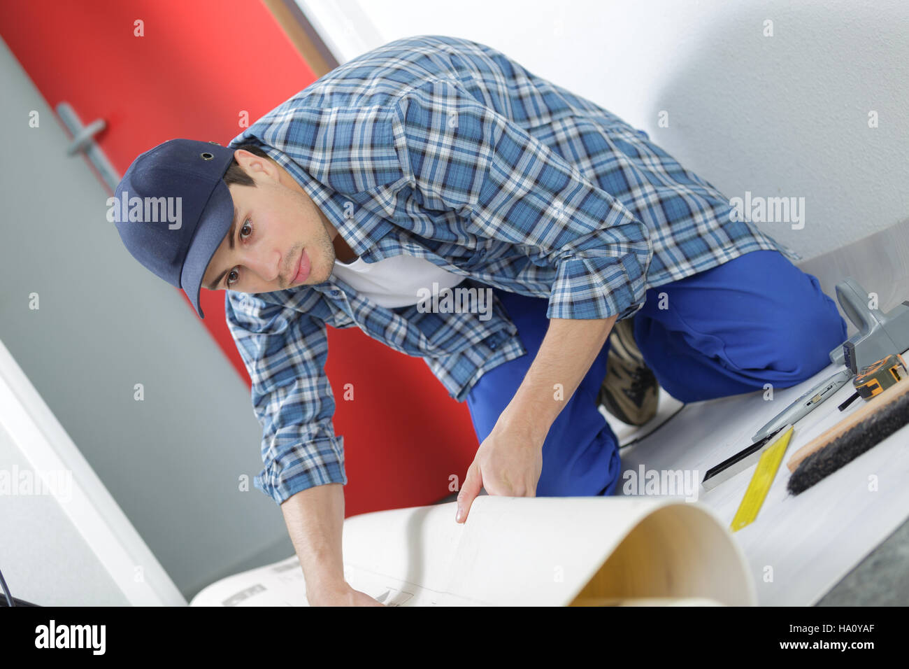 young technician installing floor at construction site Stock Photo - Alamy