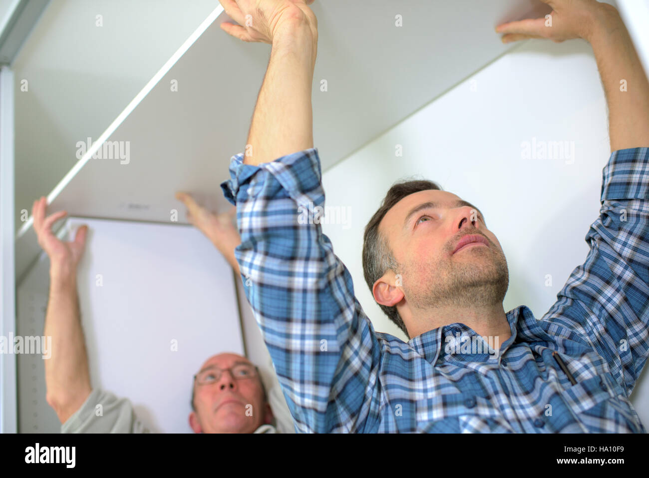 Two men assembling a wardrobe Stock Photo - Alamy